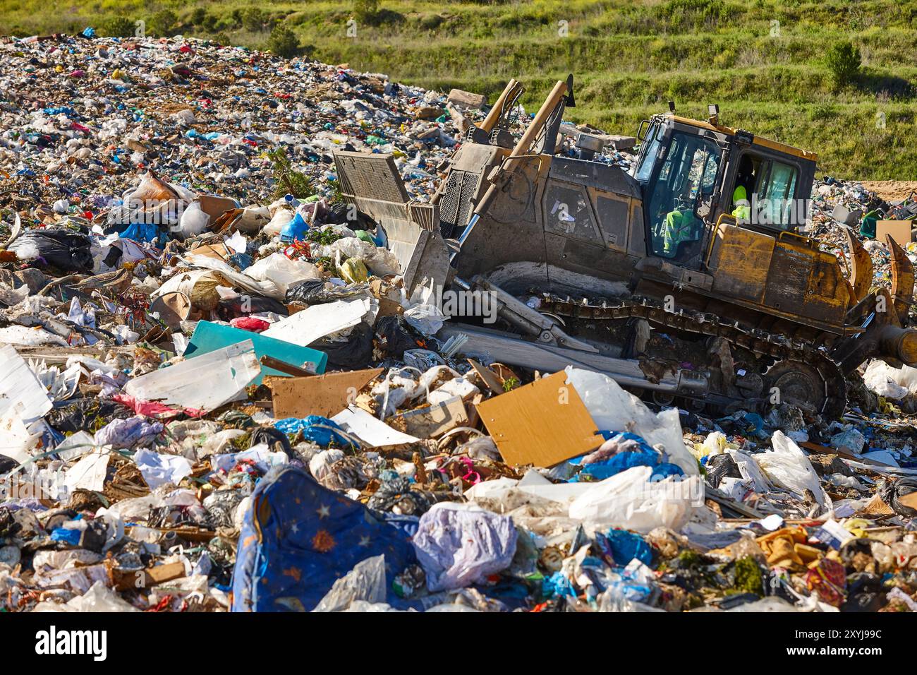 Heavy machinery shredding garbage in an open air landfill. Waste Stock ...