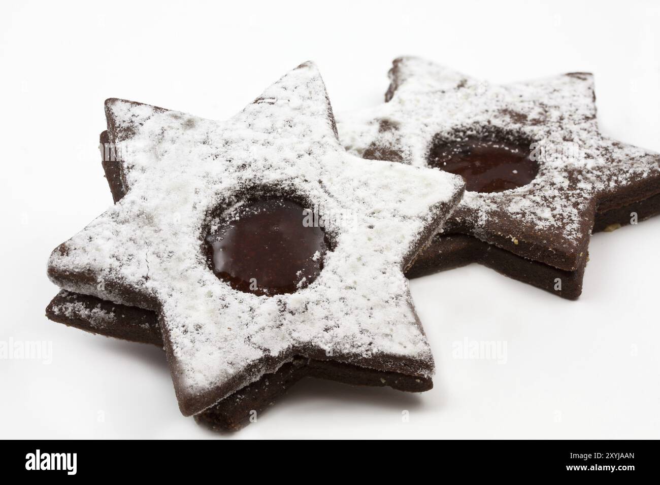Chocolate stars with filling and icing sugar on a white background ...