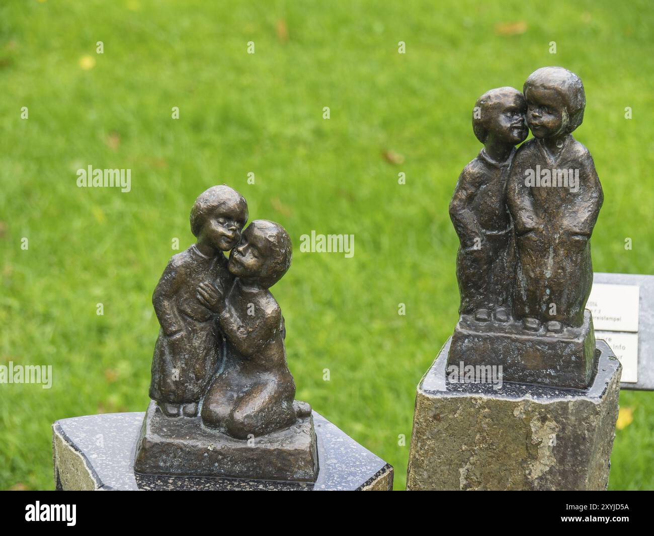Two small bronze sculptures of children in a green park, Bad ...