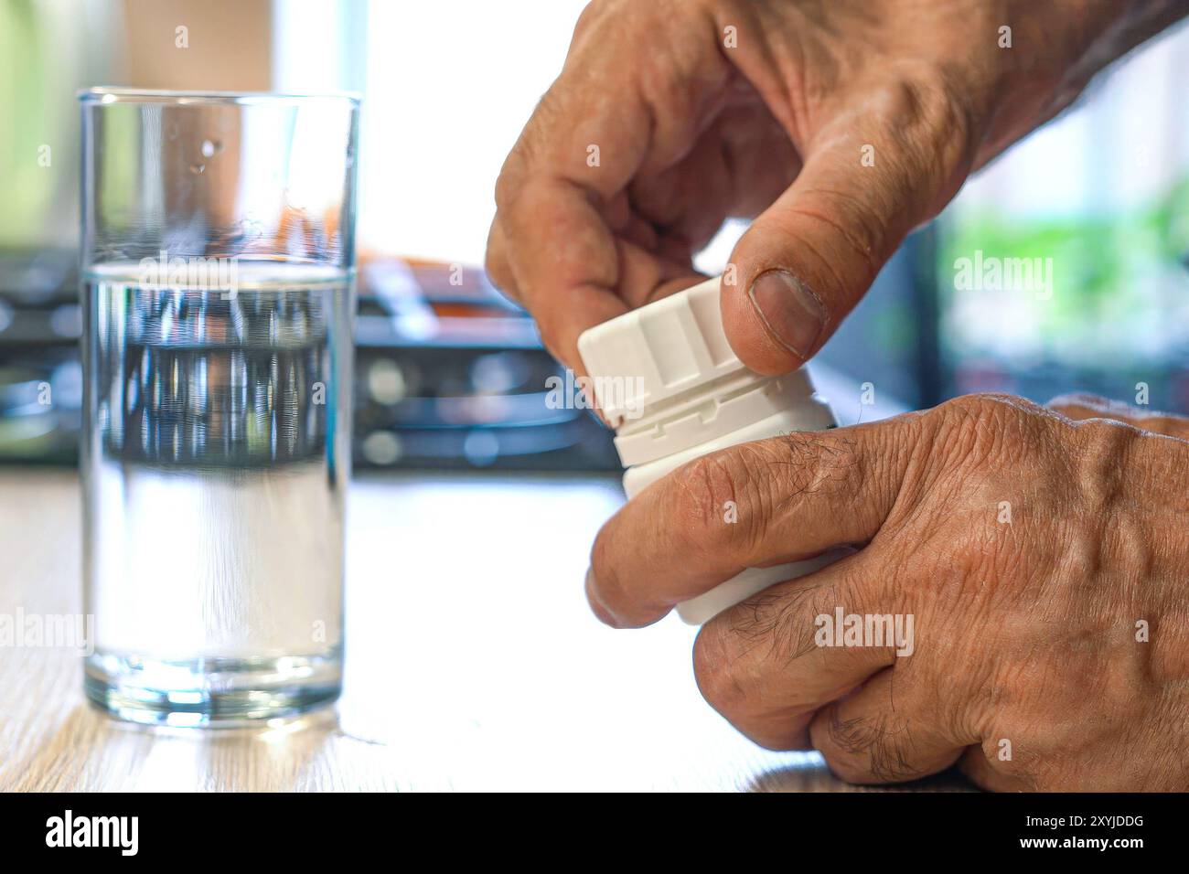 A senior person receives assistance with taking medications and water ...