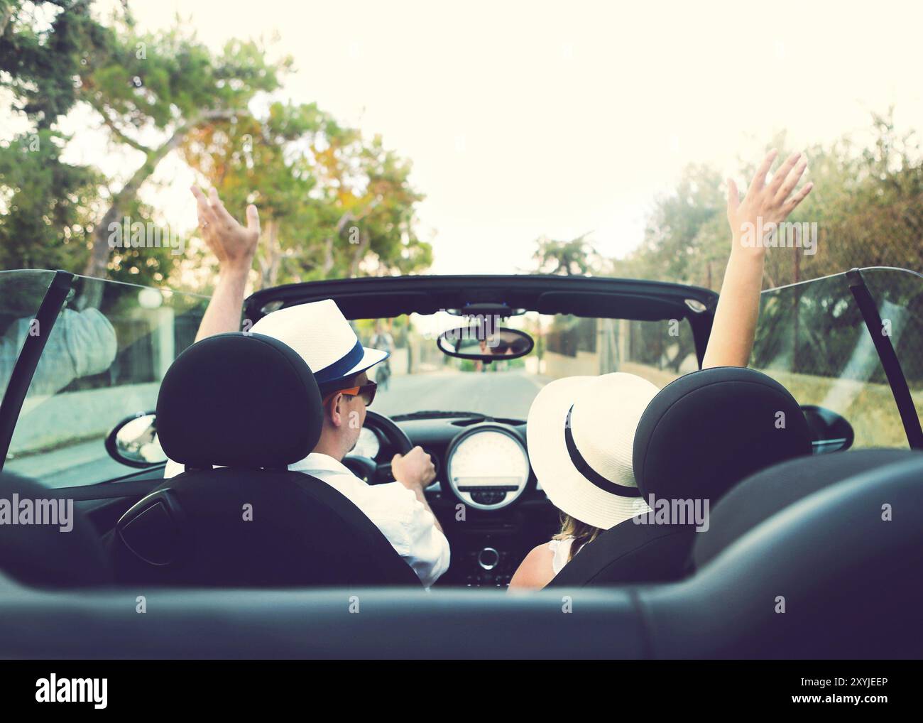Happy free couple in car driving in car cheering joyful with raised ...