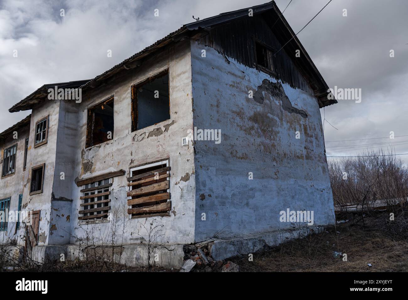 Boarded up windows. An old abandoned wooden house with boarded up windows and a crumbling roof ...