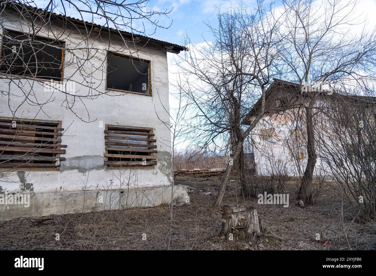 Boarded up windows. An old abandoned wooden house with boarded up windows and a crumbling roof ...
