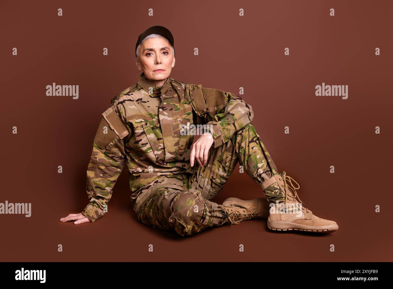 Full body photo of attractive mature woman army soldier sit floor ...