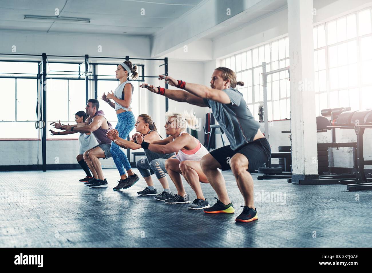 Fitness, personal trainer and group squat for exercise, healthy workout ...