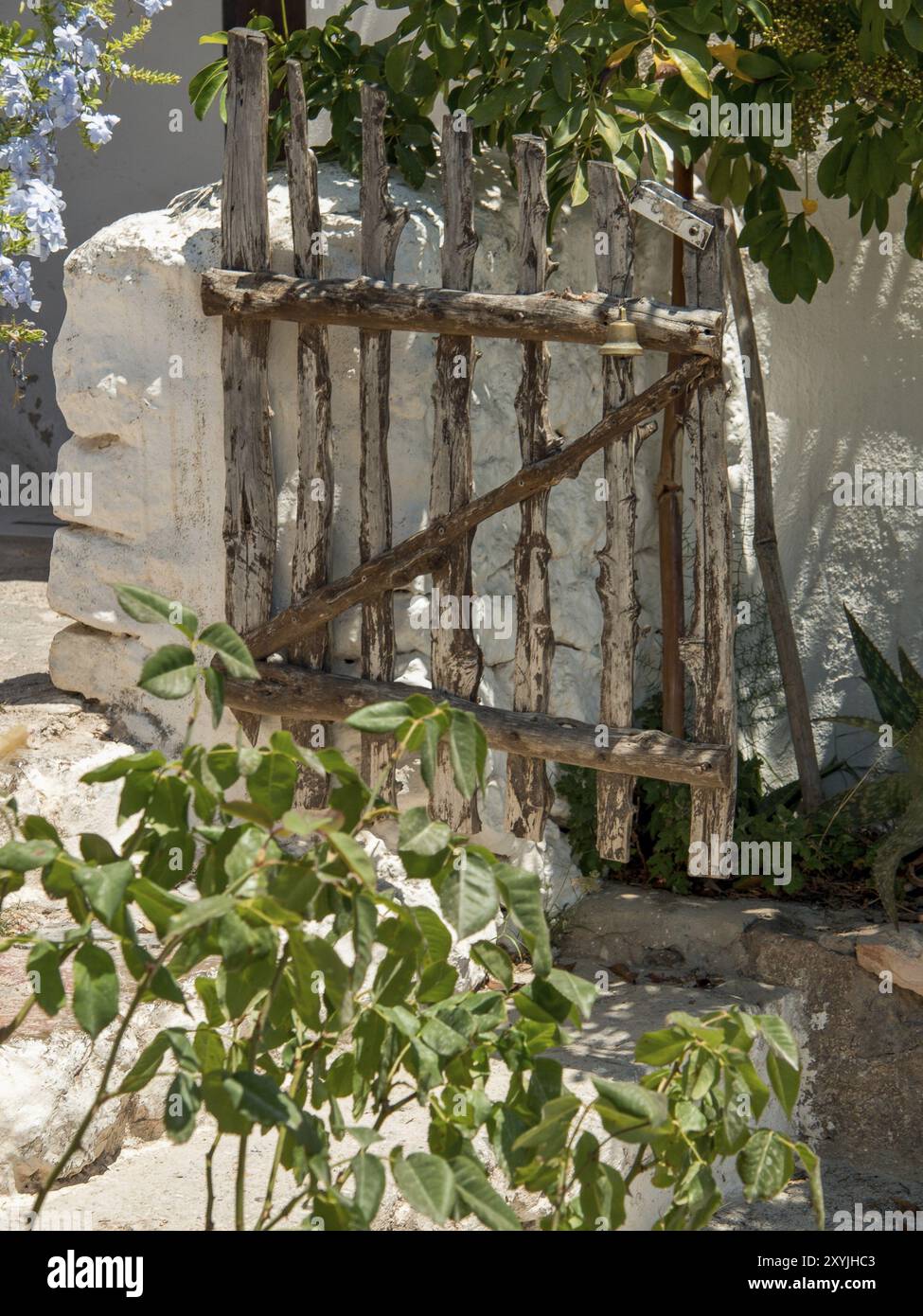 Rustic wooden gate with plants and shade in a sunny garden, ibiza ...