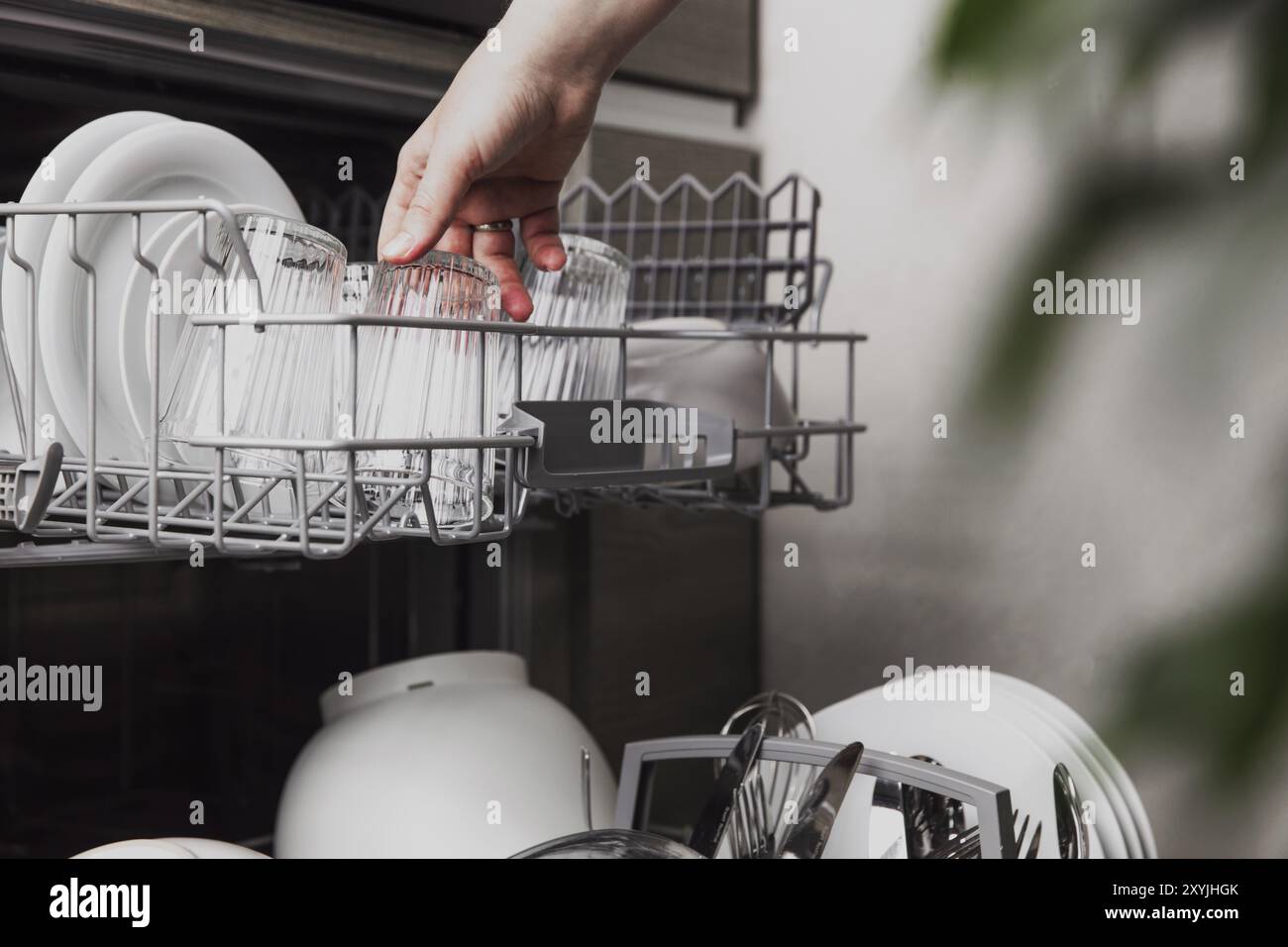 Close-up of female hand loading dished to, empty out or unloading from ...