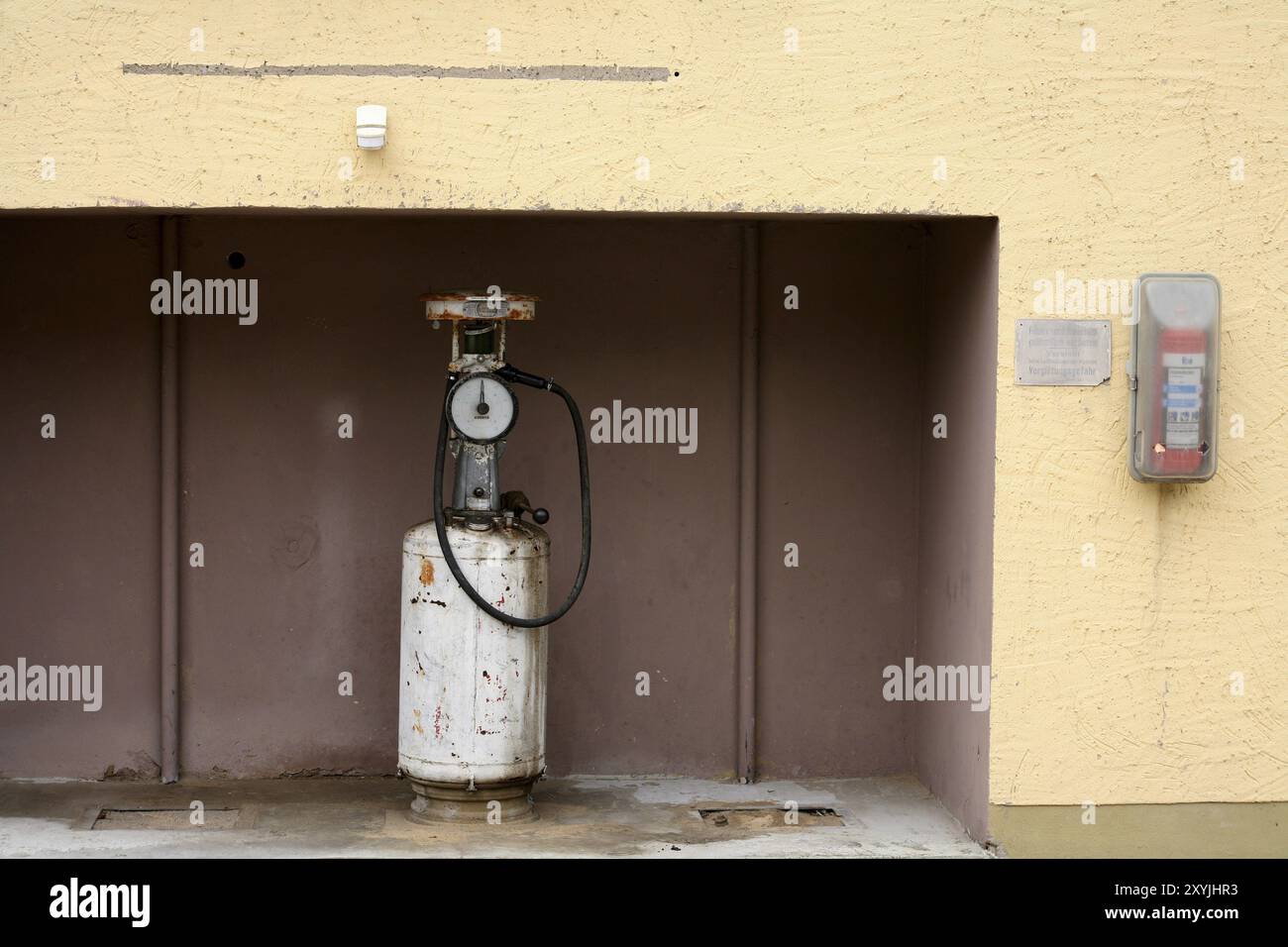 Rusty petrol pump with fire extinguisher Stock Photo - Alamy