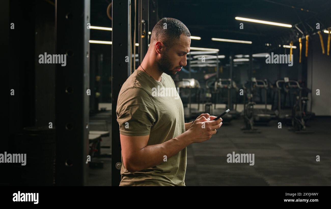 American Latino ethnic man browsing smartphone serious athlete fit ...