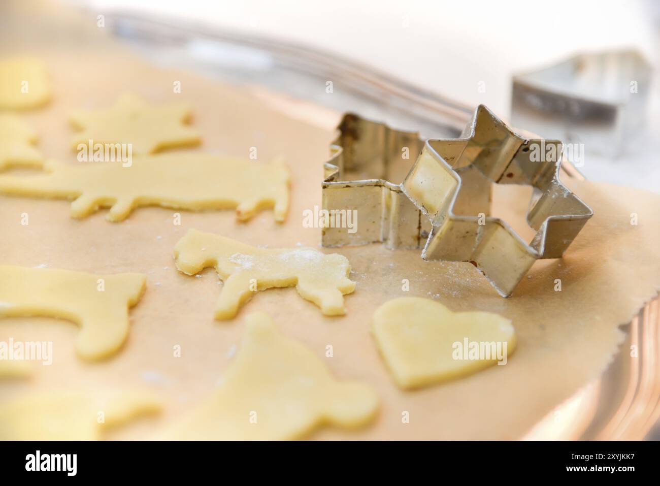 Christmas biscuits cut out in front of baking with cookie cutters in ...