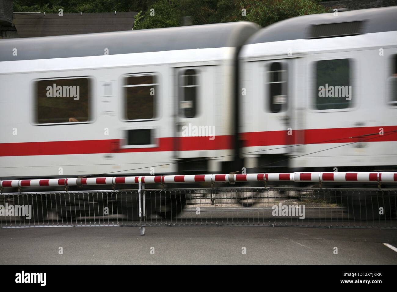 Rushing train with barrier Stock Photo - Alamy