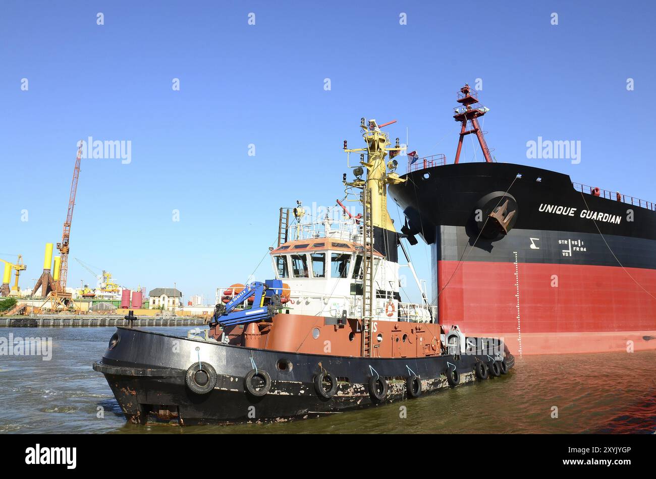 The oil tanker Unique Guaridan is towed in the harbour basin by a ...