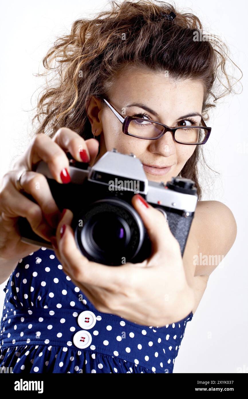 Beautiful woman in a blue polka dot dress with camera Stock Photo - Alamy