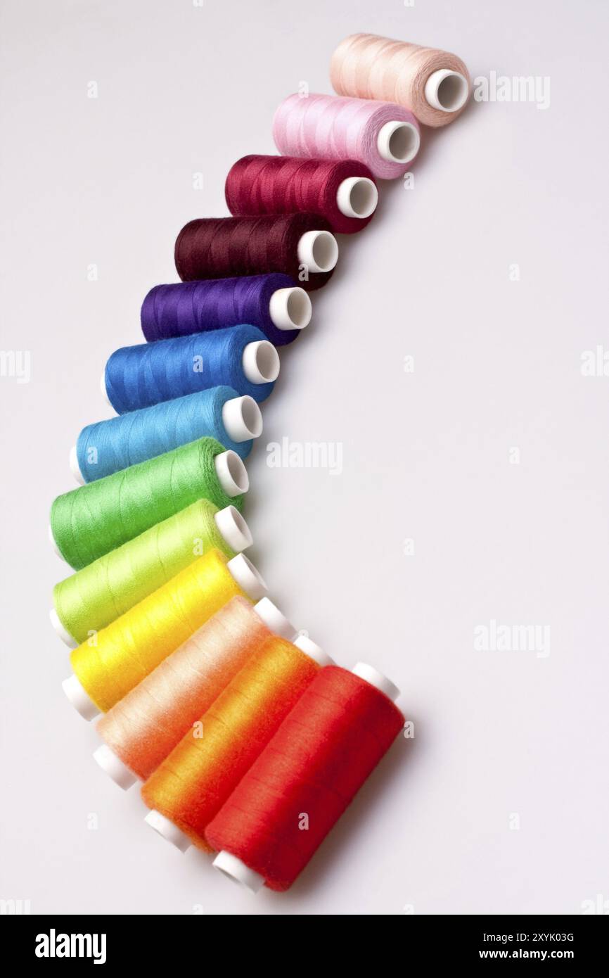 Multi-colored rainbow threads for sewing Stock Photo - Alamy