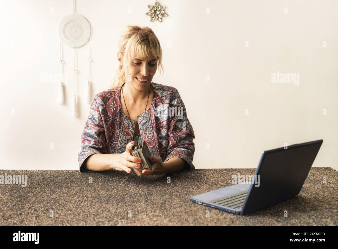Tarot reader mixing the cards in an online session with her laptop in ...