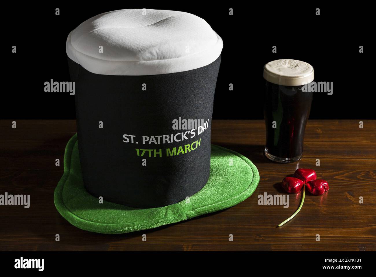 St Patrick day with a pint of black beer, hat and shamrock over a table ...