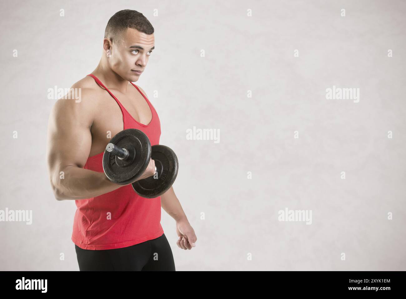 Fit athlete doing standing dumbbell curls for training his biceps ...