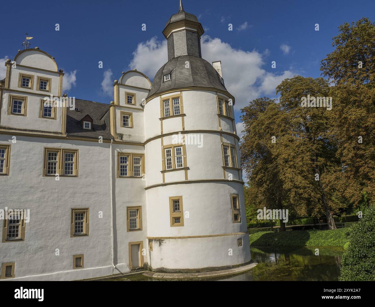 White castle with yellow accents and a round tower in front of a sunny ...
