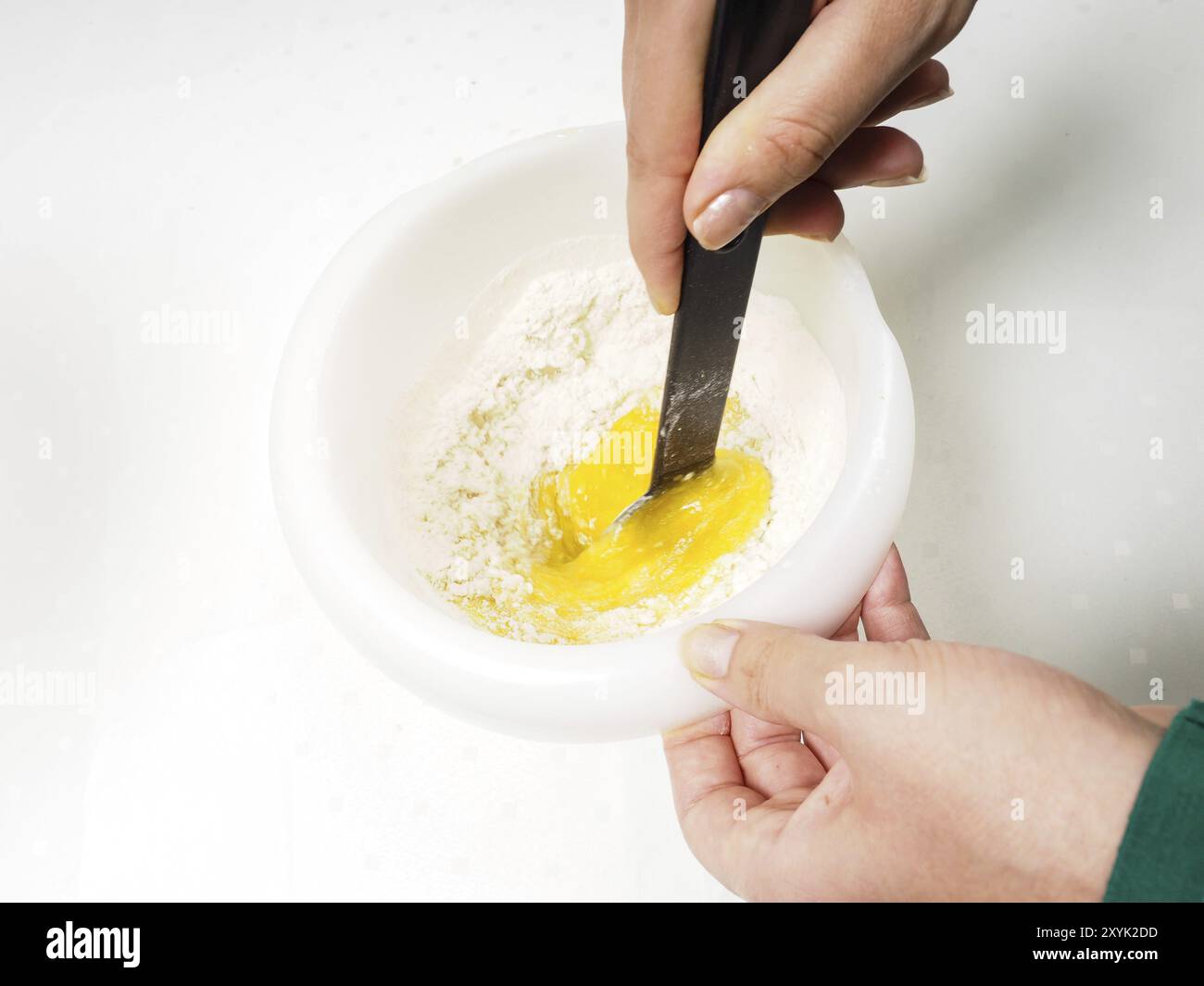 Female person blending flour with egg yolk and melted butter with a ...
