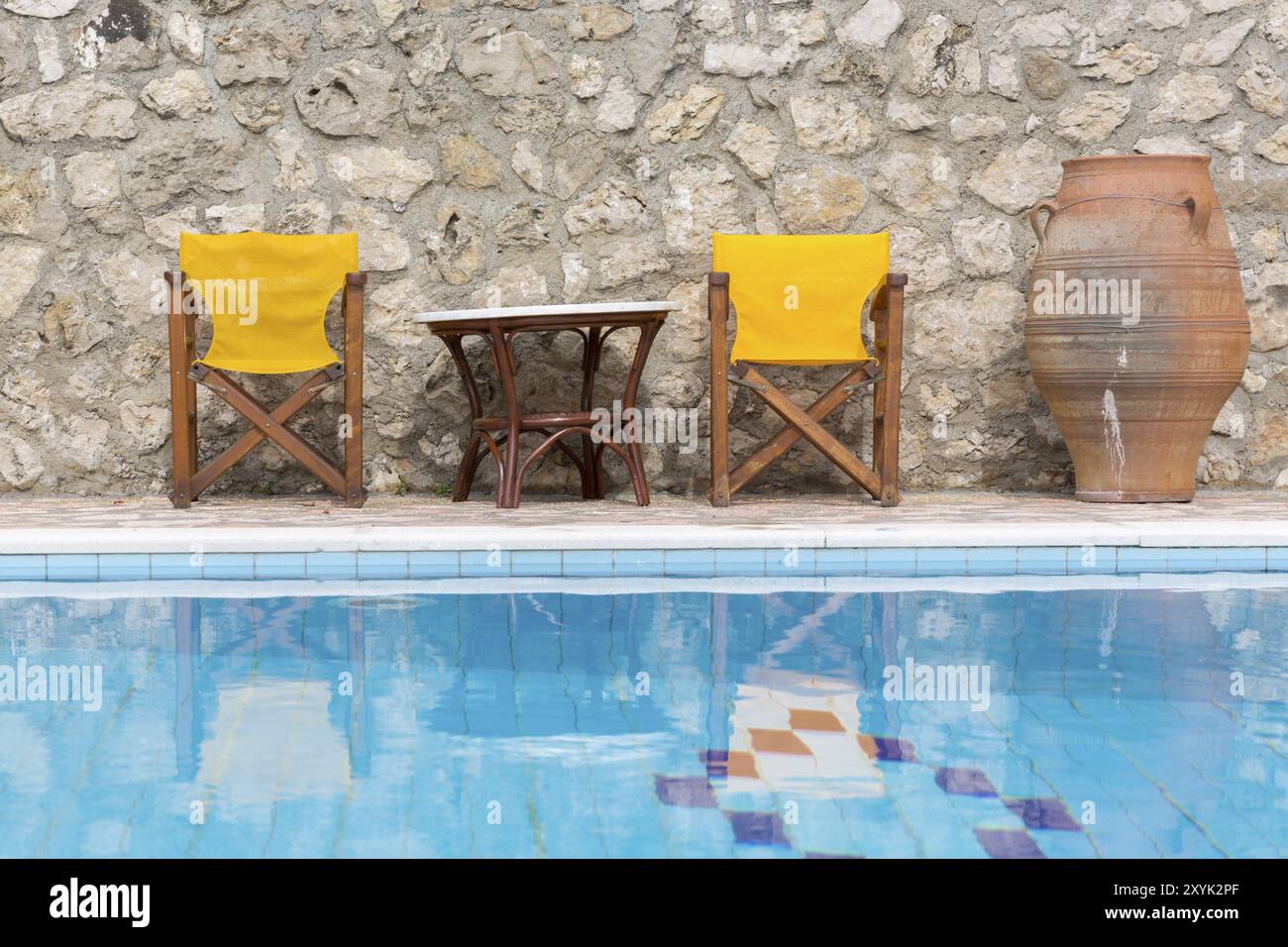 Swimming pool with table and chairs Stock Photo - Alamy