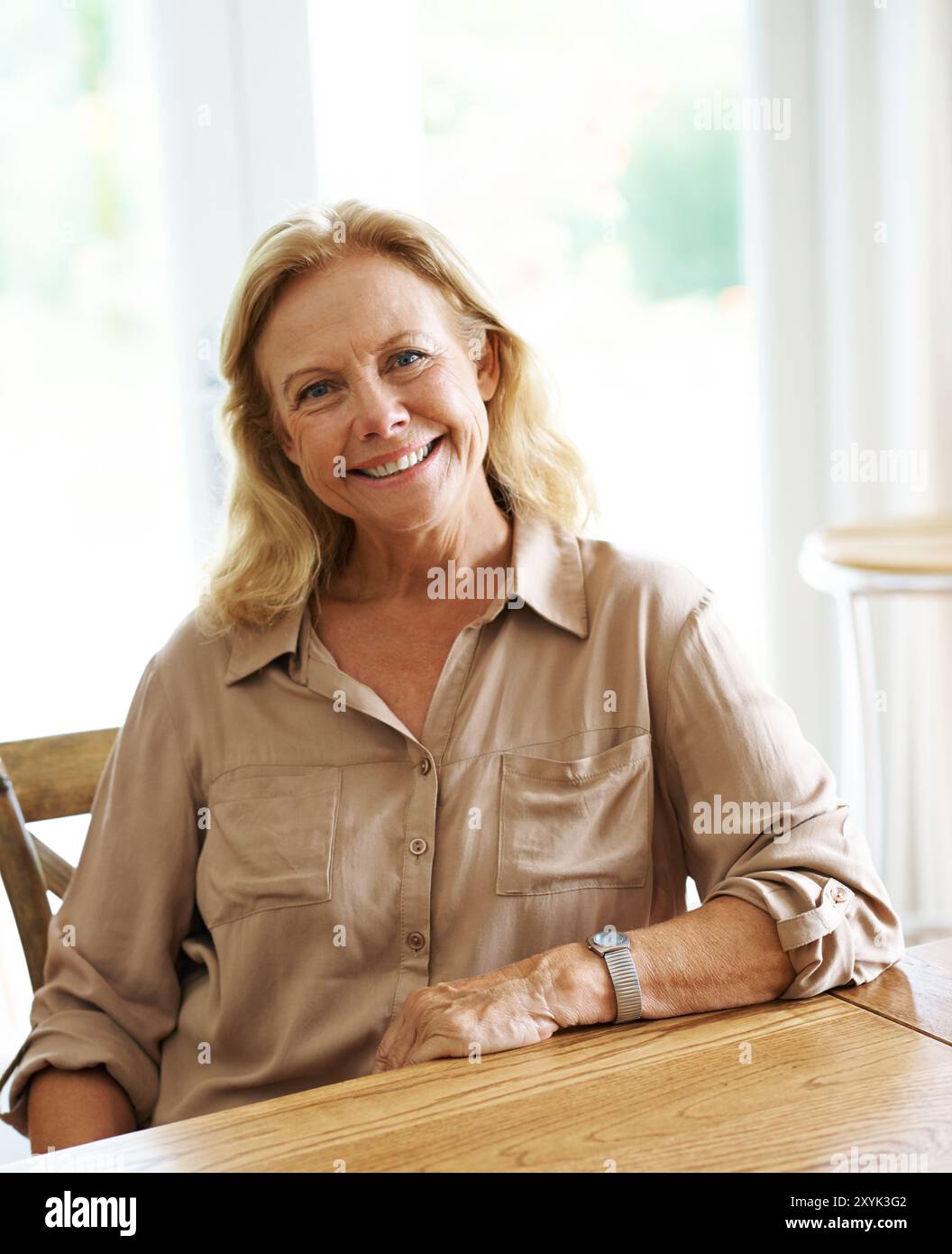Portrait, relax and smile with mature woman at dining room table of ...