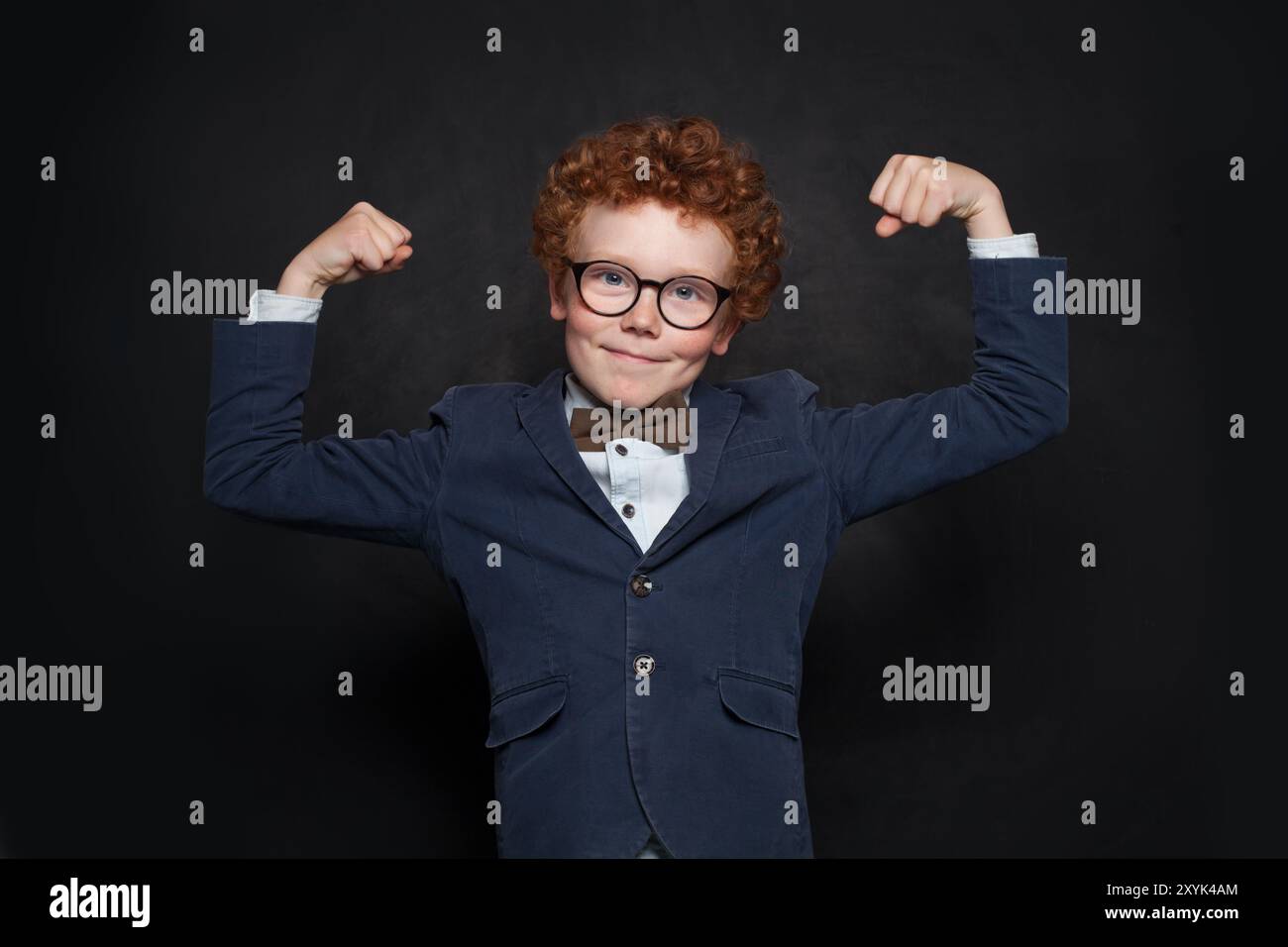 Funny strong successful child boy showing his muscles. Little kid boy ...