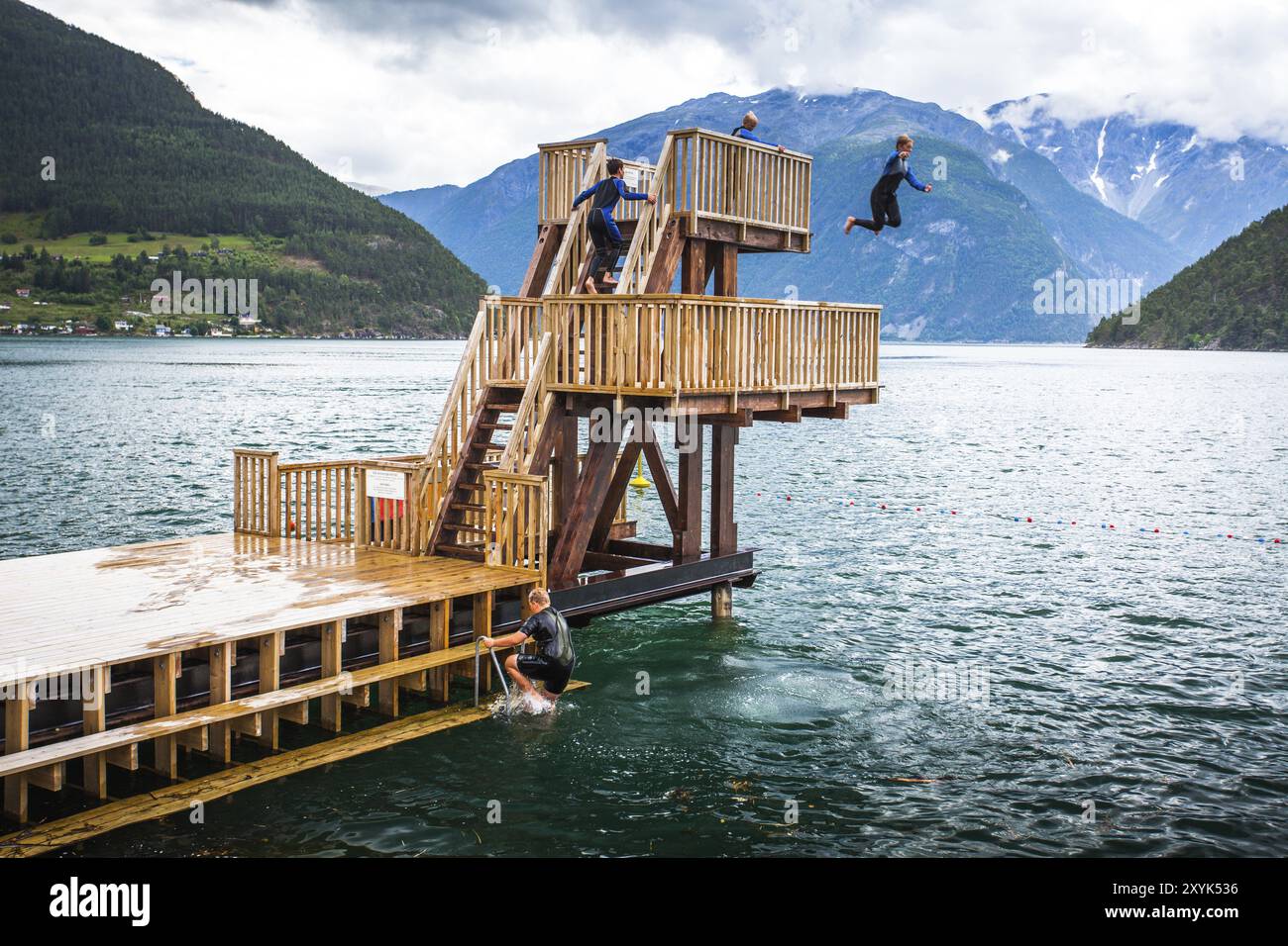 Boys jumping from a diving platform Stock Photo - Alamy