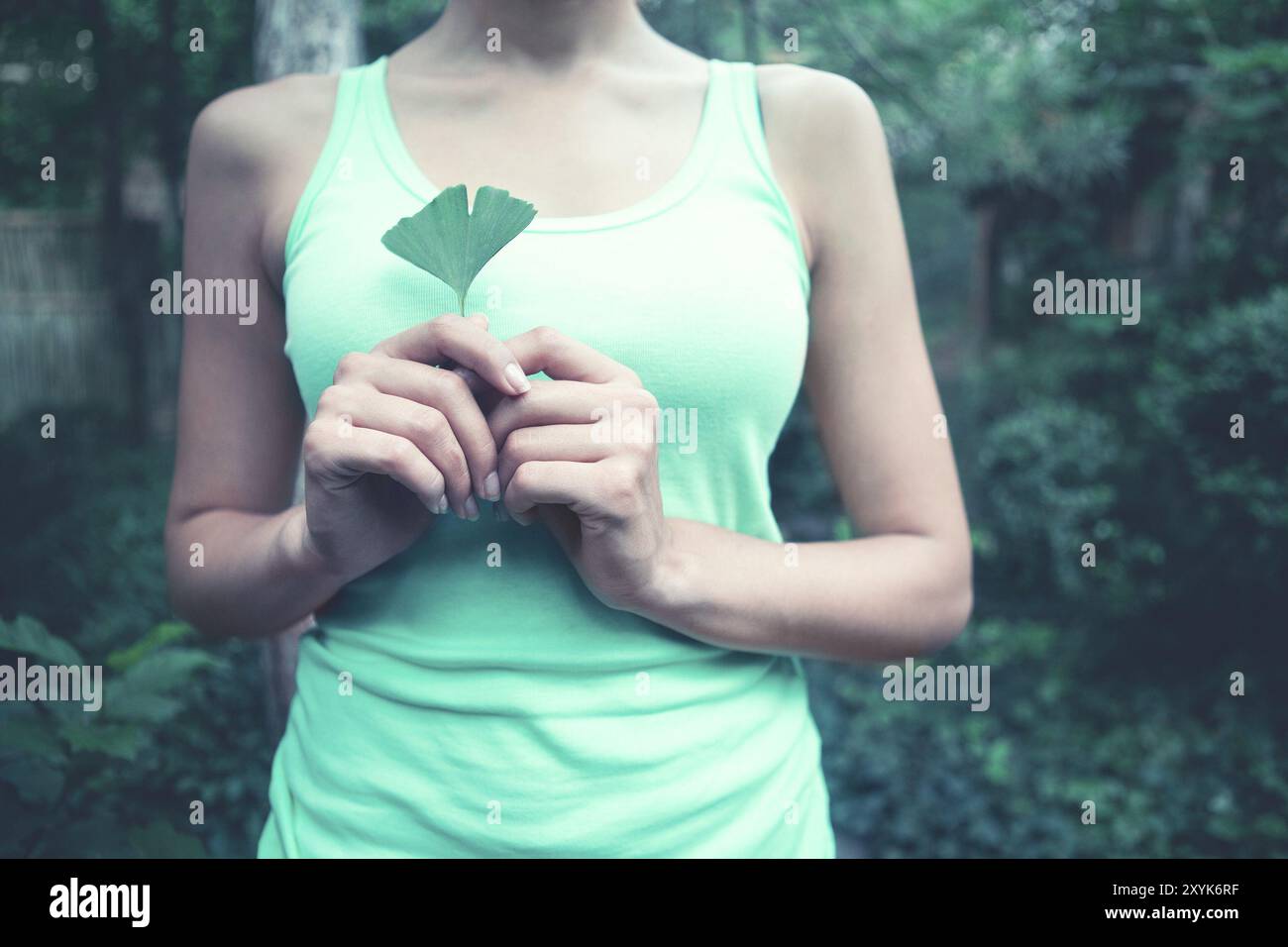 Closeup crop woman in green clothes holding fresh leaf beautiful shape ...