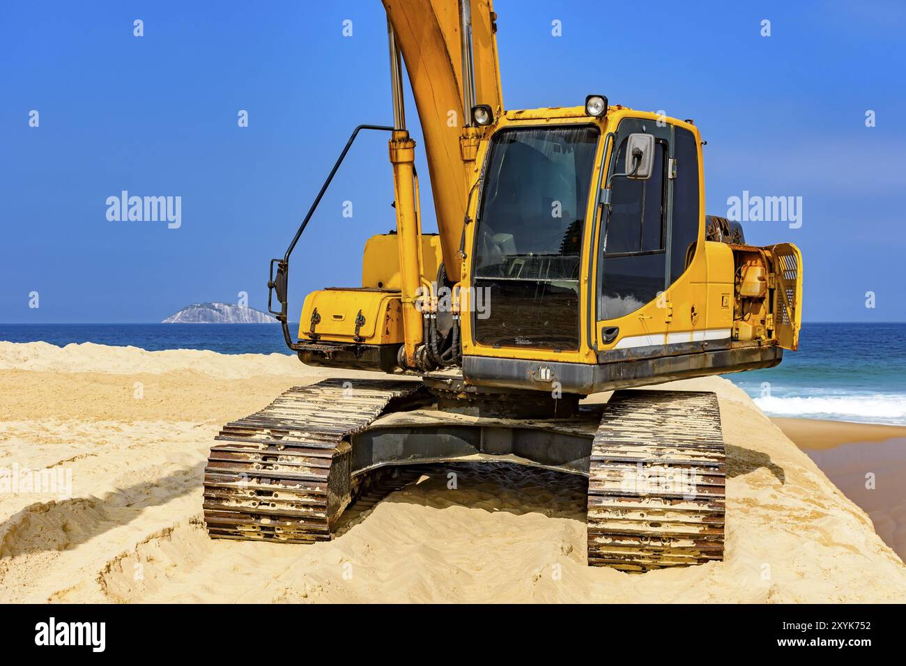 Yellow excavator cabin and arm over sand at beach in a sunny day Stock ...
