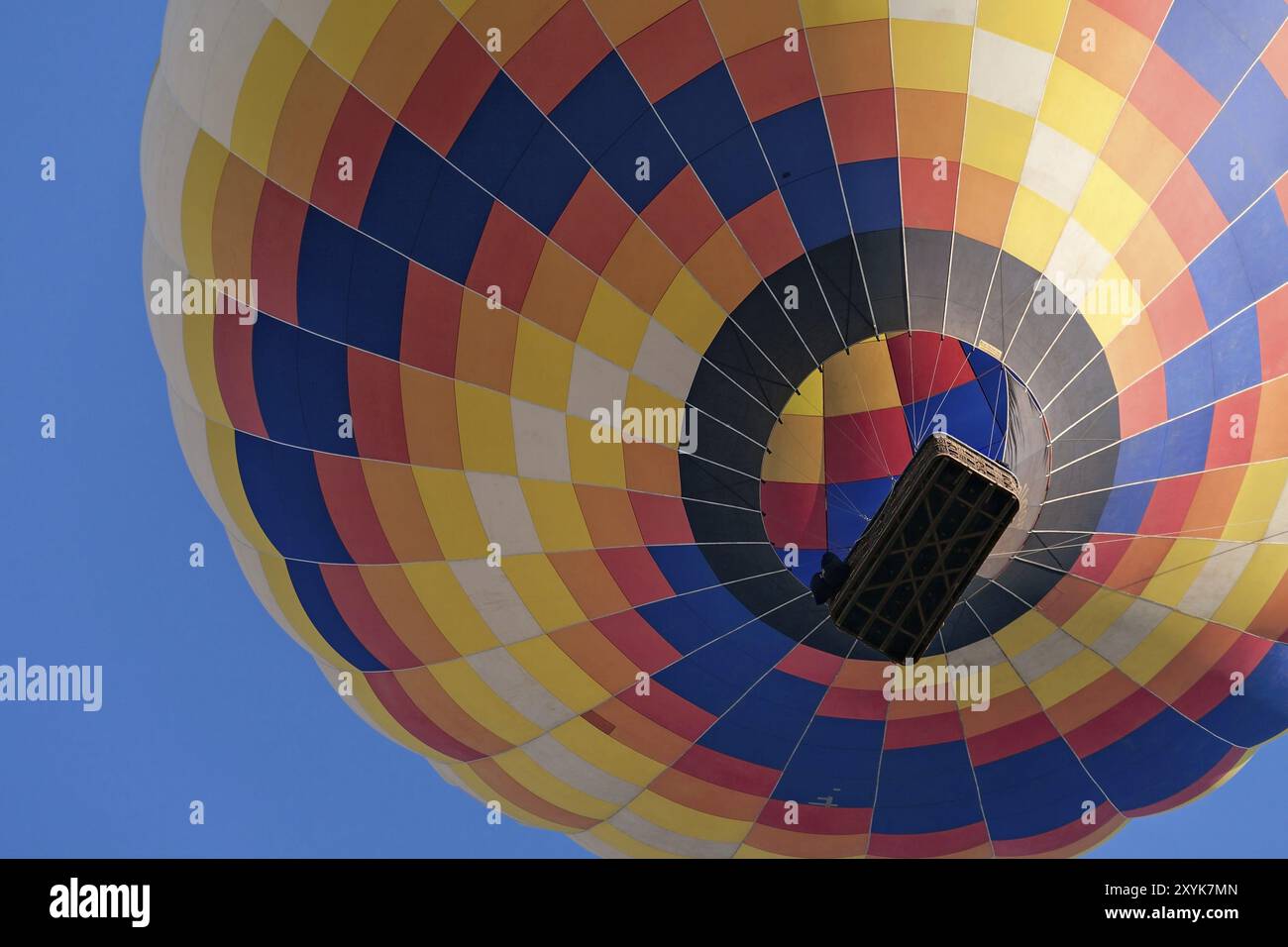 Closeup of a colorful hot-air balloon in flight seen from below against ...