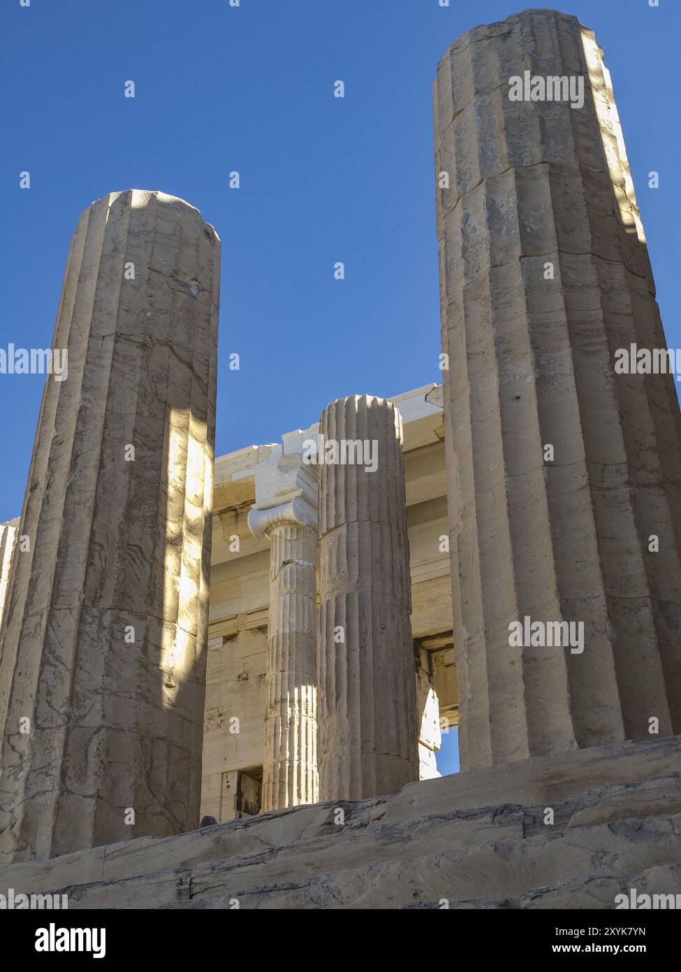 Majestic ancient columns and stone structures under a blue sky, athens, greece Stock Photo - Alamy