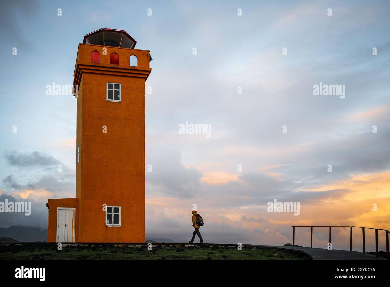 man standing in front of orange lighthouse in Iceland Stock Photo - Alamy