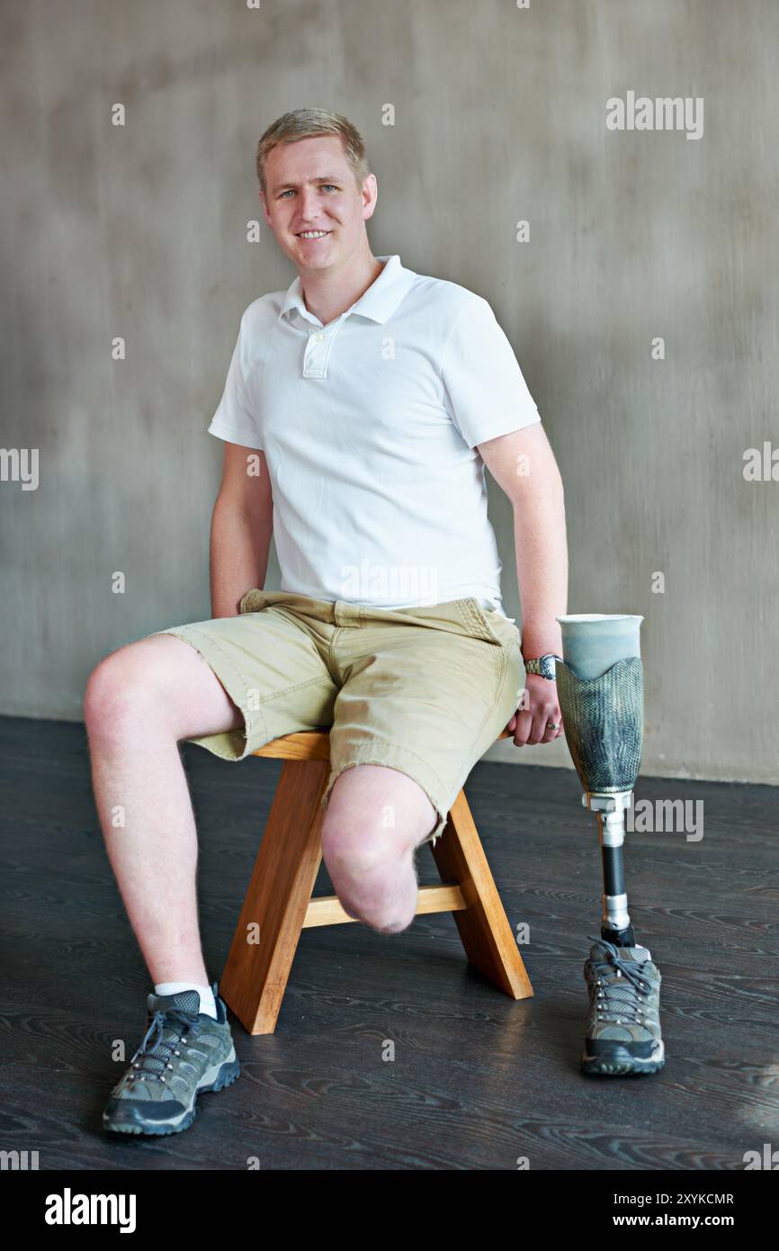 Man, portrait and amputee smile with prosthetic leg in gym, sitting ...