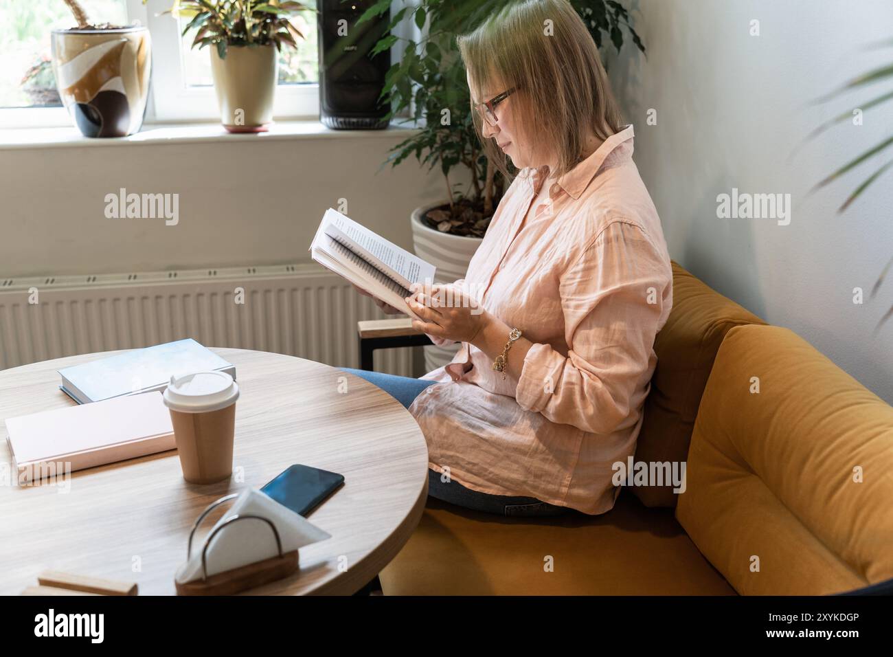 Woman alone reading sitting cafe table hi-res stock photography and ...