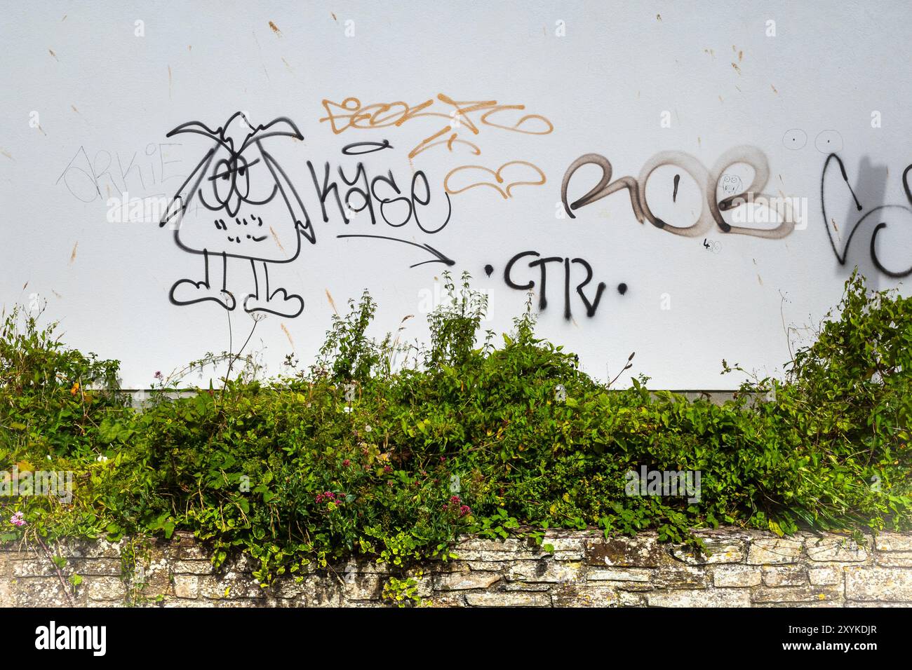 Ugly graffiti and tags sprayed on a wall in Newquay town centre center ...