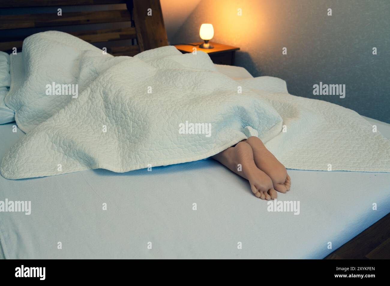 Beautiful feet under the white blanket. Relaxation of a woman in Stock ...