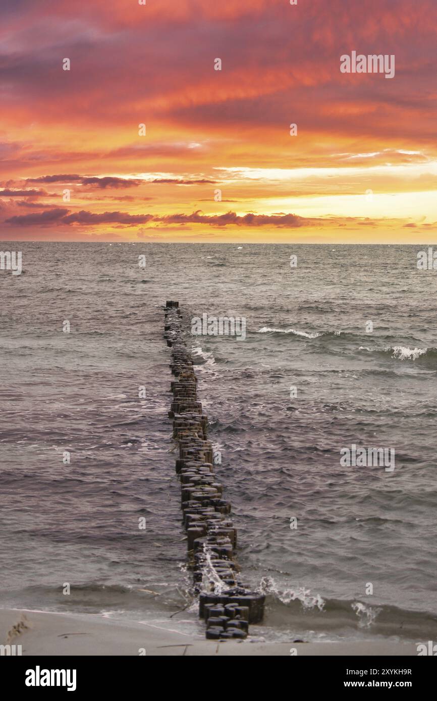 Groynes jut out into the Baltic Sea. Sunset on the horizon. Wooden logs ...