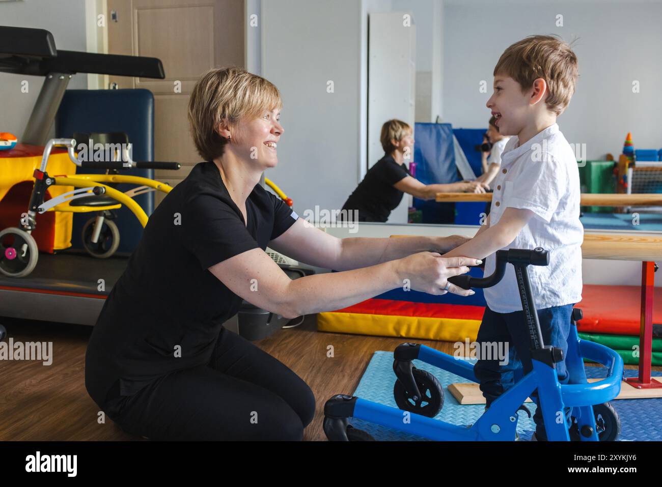 Cute little boy with movement disorders stands using a walker while ...