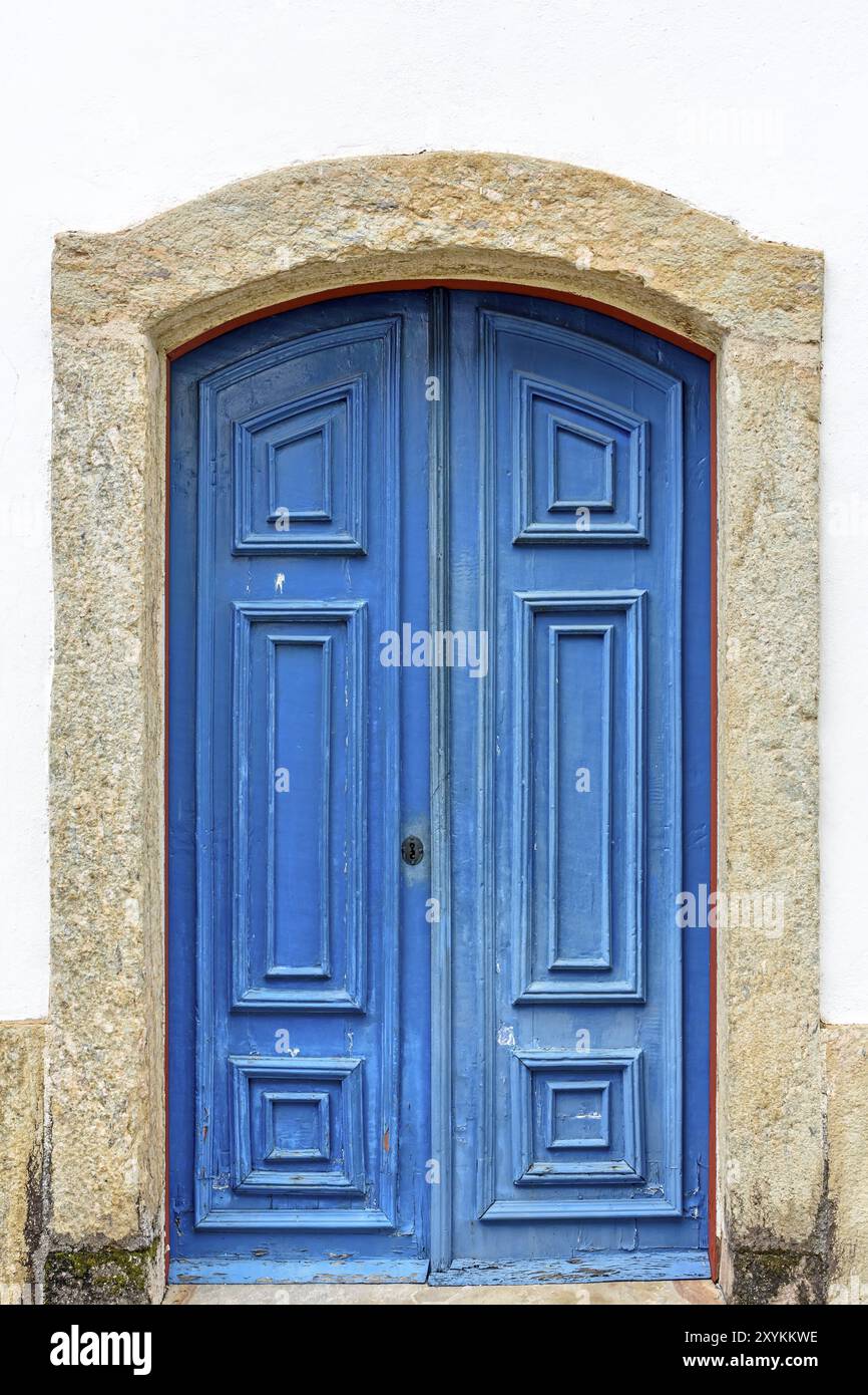 Old and aged historic wooden blue church door in the city of Ouro Preto ...