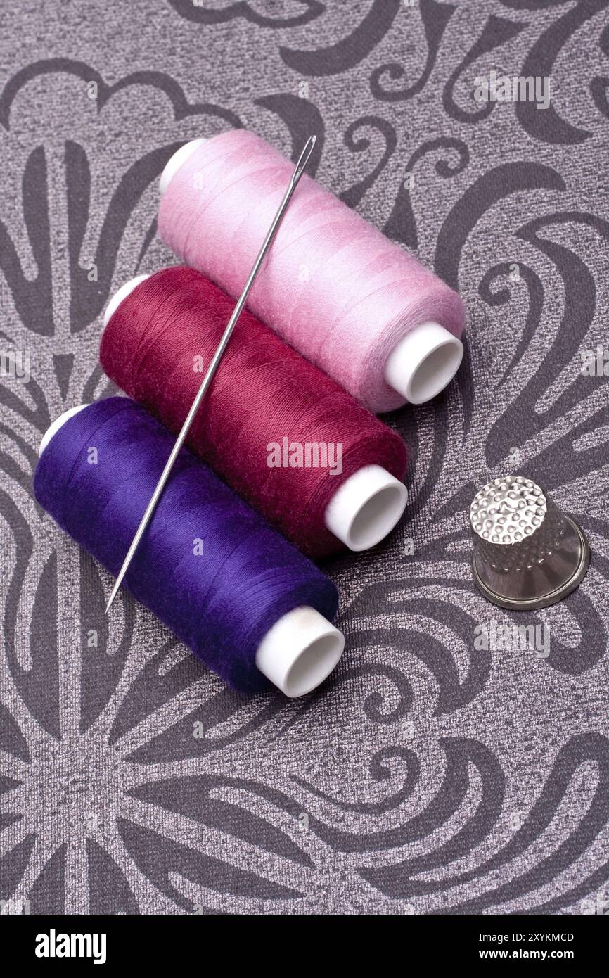 Multi-colored rainbow threads for sewing with needle and thimble Stock ...