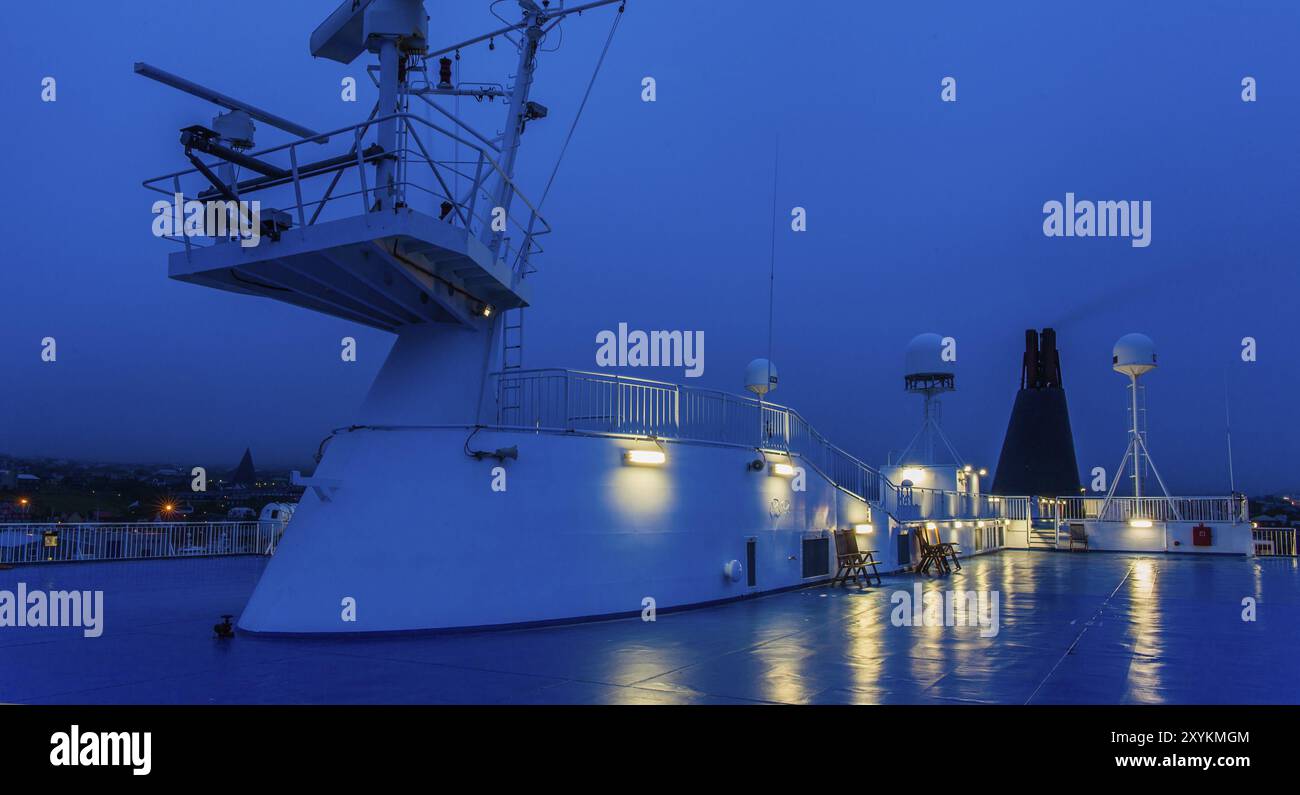 Illuminated white and blue sun deck of a ferry at nighttime Stock Photo ...