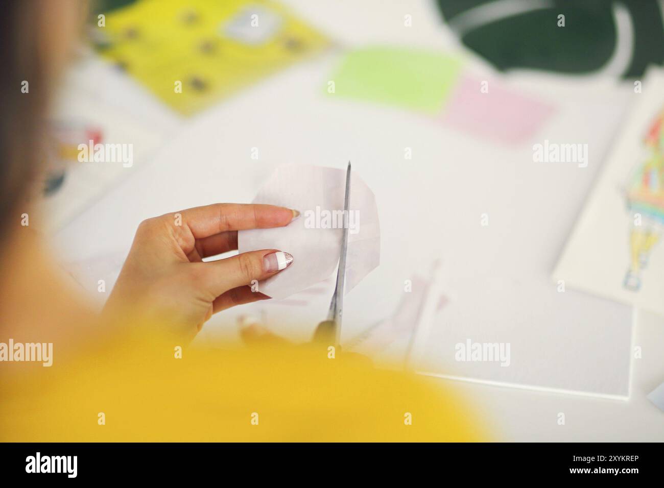 Young brunette woman creating her Feng Shui wish map using scissors ...