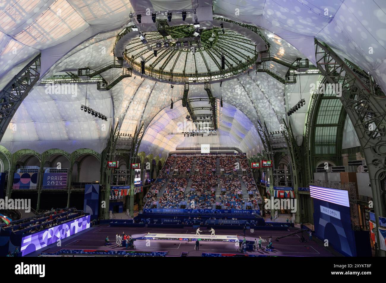Fencers stand in an en garde position at the start of a bout at the ...