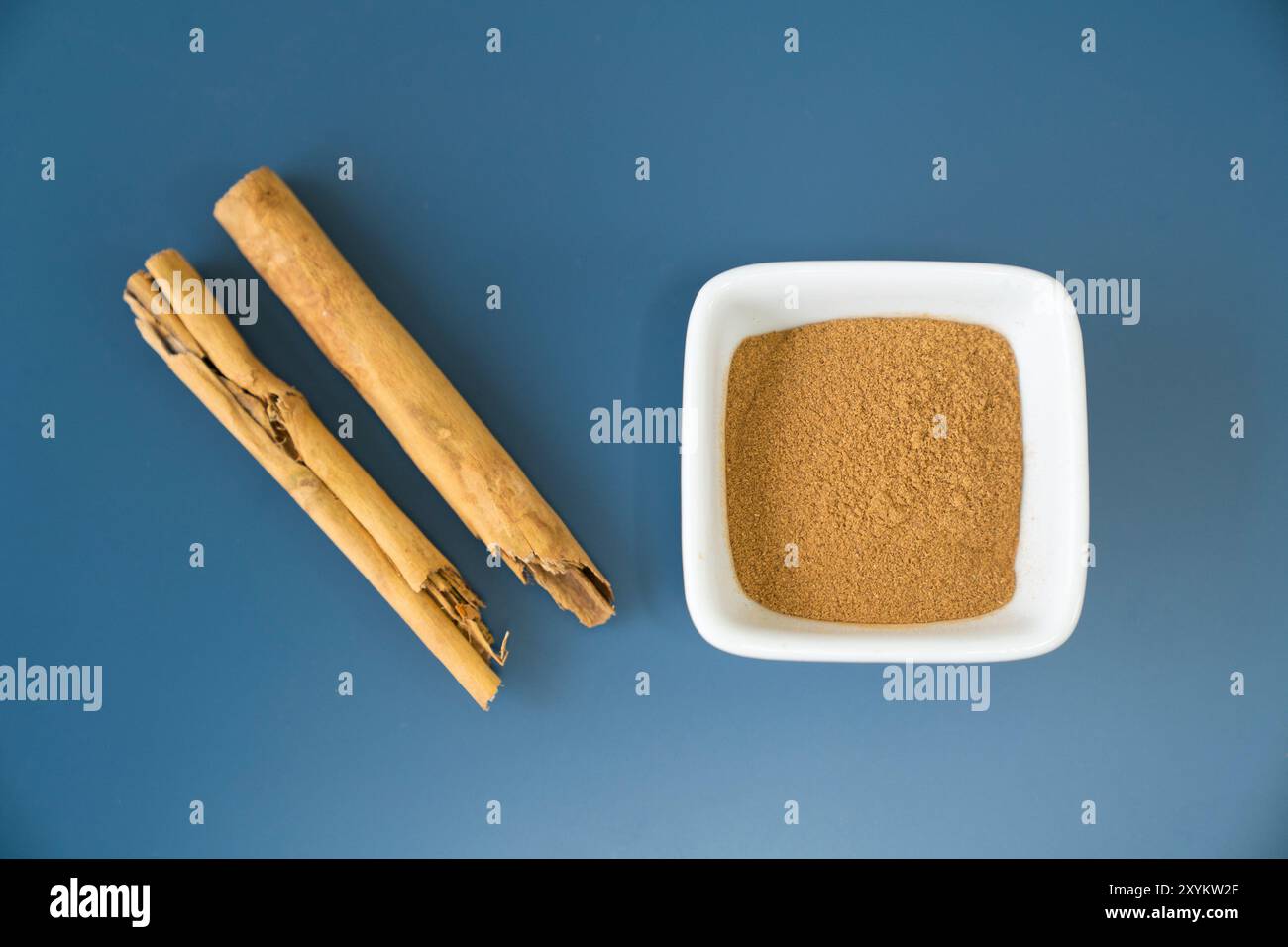Dried cinnamon on blue background with cinnamon sticks still life Stock ...