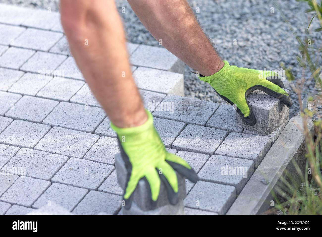 Worker building a new interlocking pavement from concrete paving, a new ...