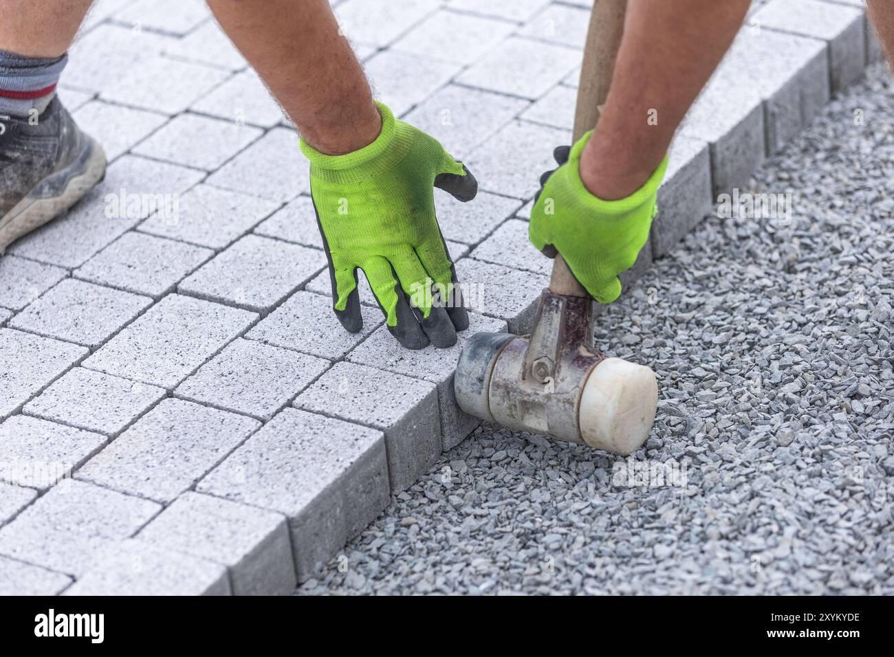 Man laying paving tiles on the floor using a rubber mallet Stock Photo ...