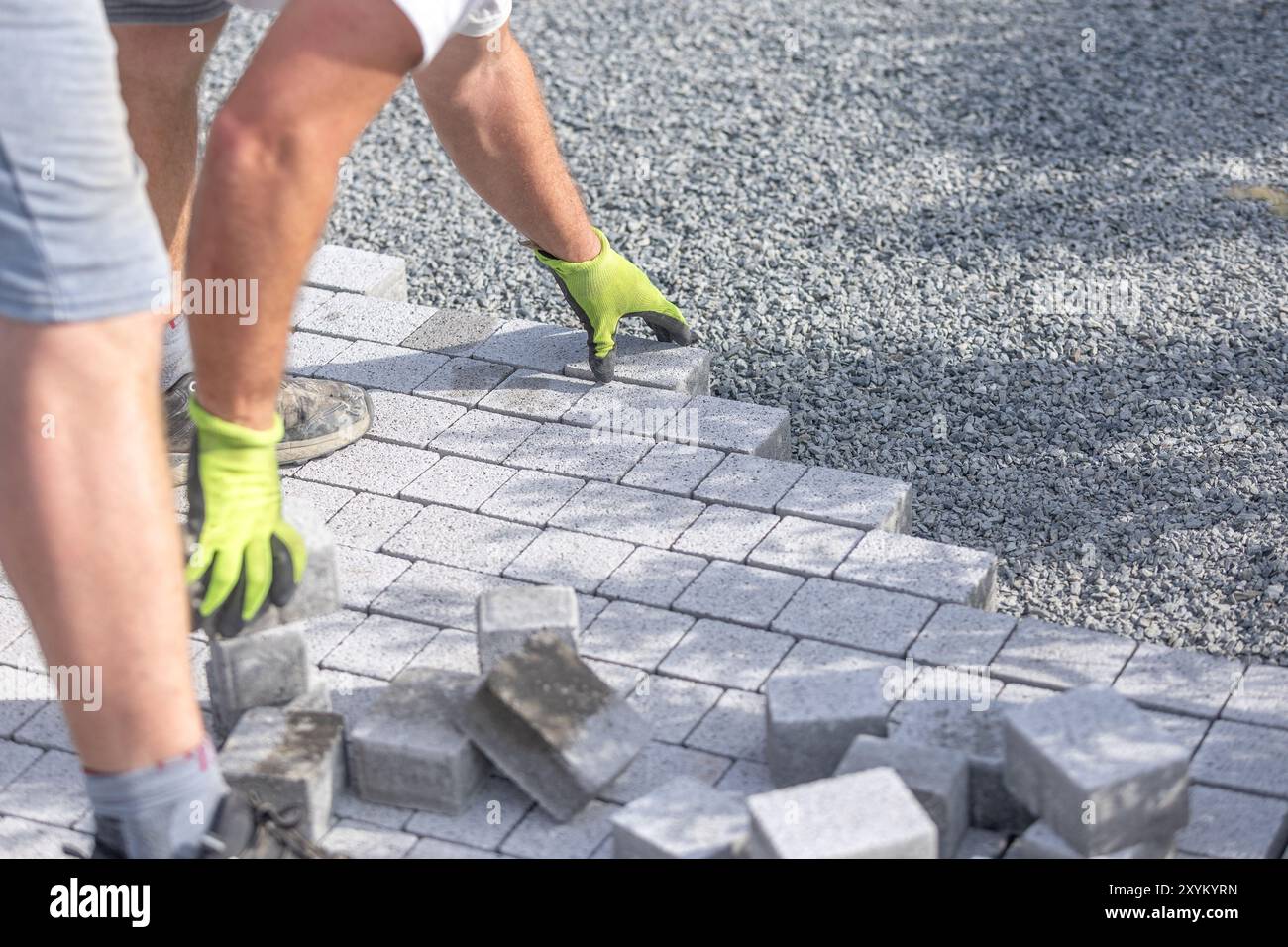 Worker building a new interlocking pavement from concrete paving, a new ...