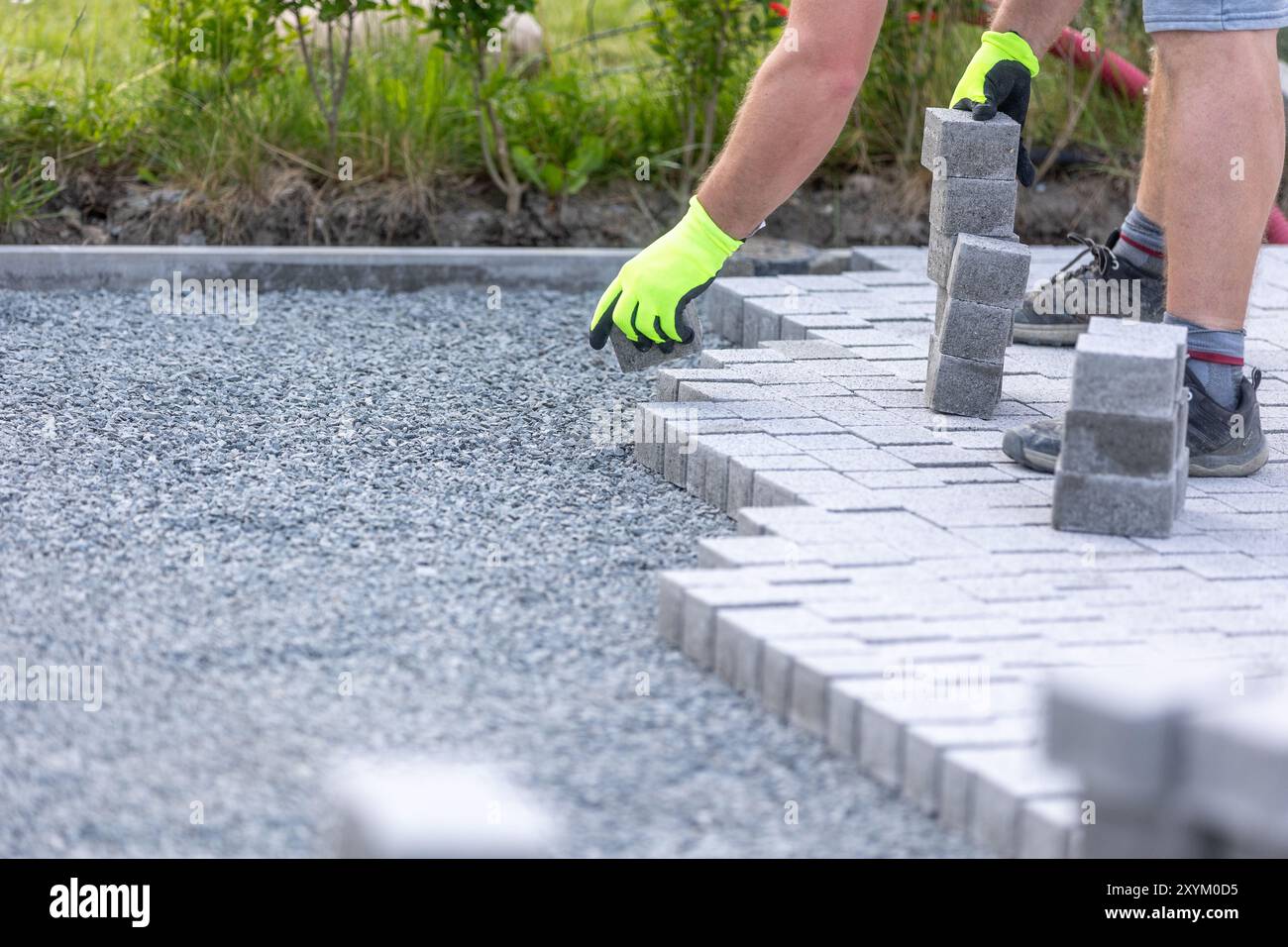 Worker building a new interlocking pavement from concrete paving, a new ...