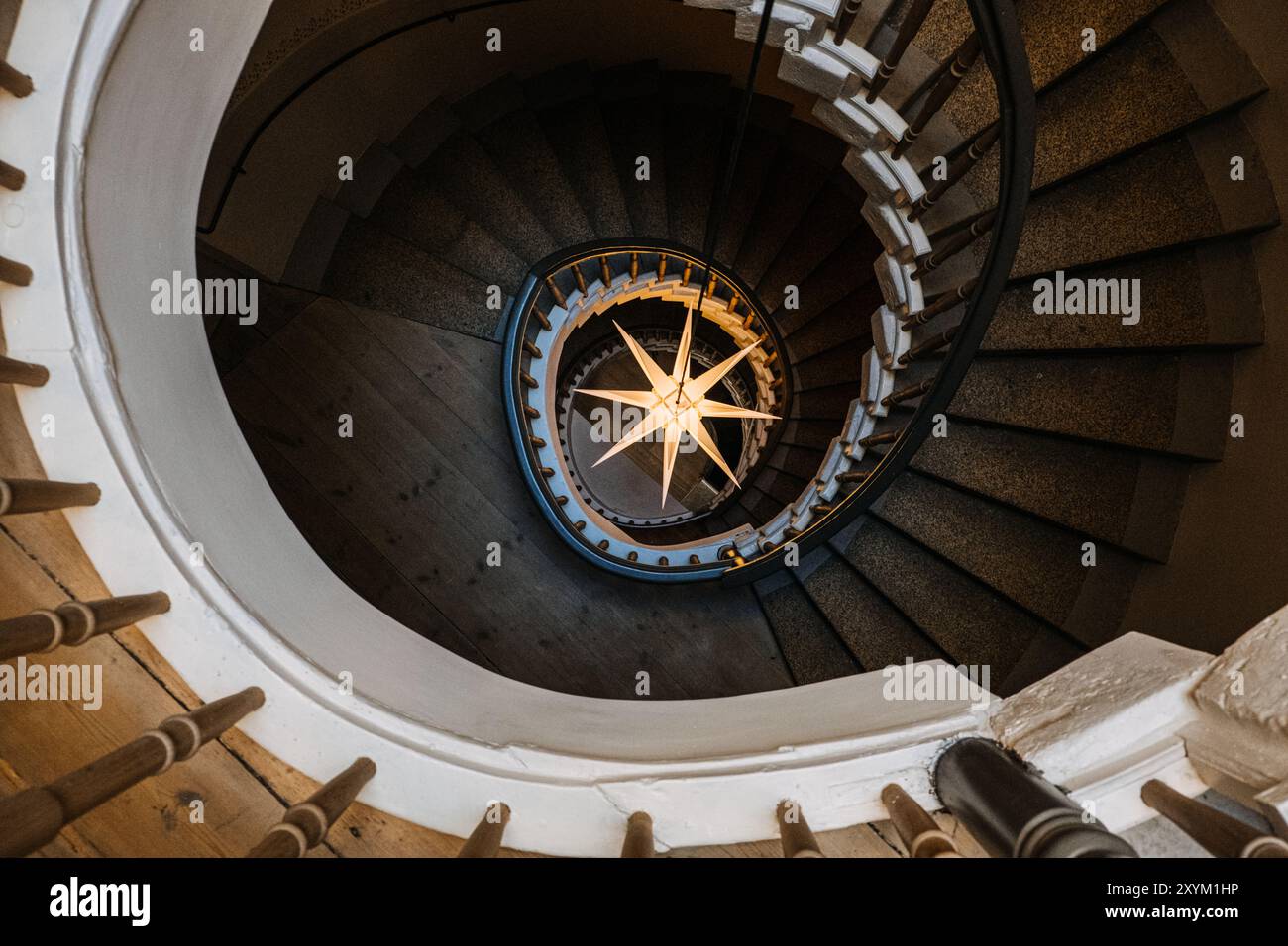 Looking down spiral staircase with star-shaped light fixture ...