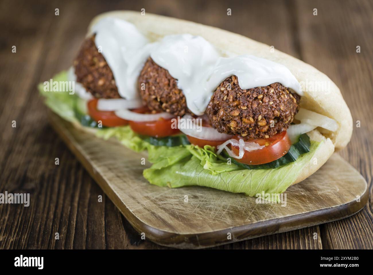 Wooden table with a fresh made Falafel Sandwich (selective focus, close ...